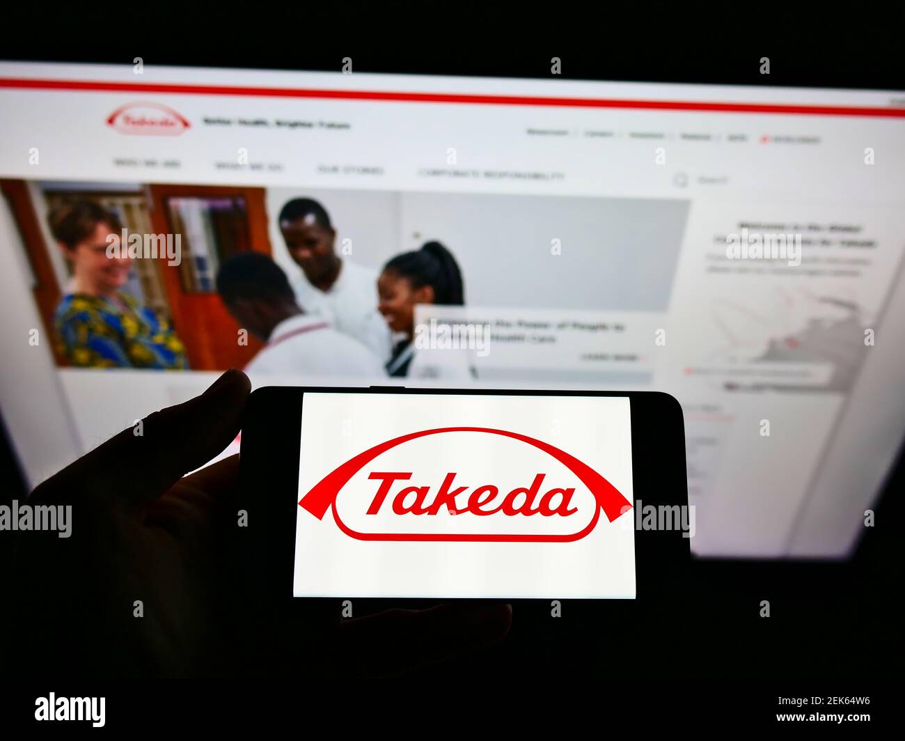 Person holding smartphone with logo of Japanese Takeda Pharmaceutical ...