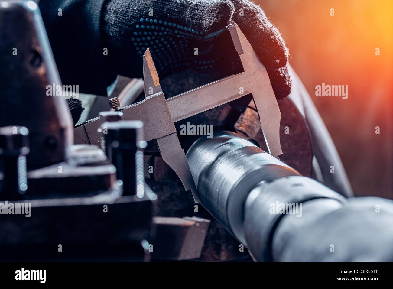 Operator measures reel of workpiece with vernier caliper. Process CNC ...
