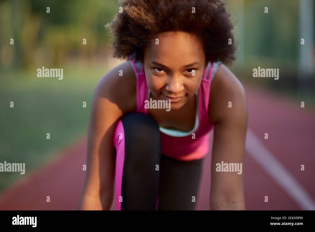 Cute girl runner standing in start position before the sprint Stock ...