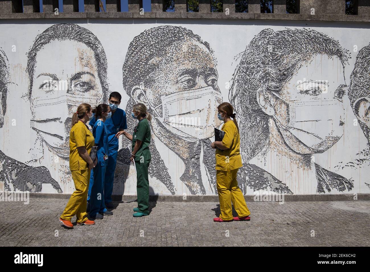 Team of health professionals speak, while standing next to the graffiti ...