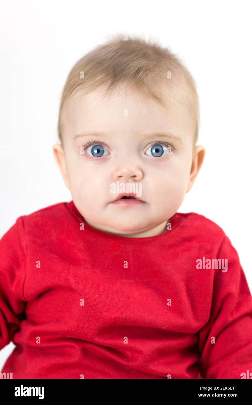 A child with wide open eyes looks directly white background Stock Photo ...