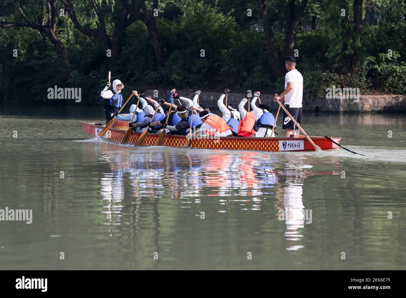 Participants practise dragon boat on a river for competition in a ...