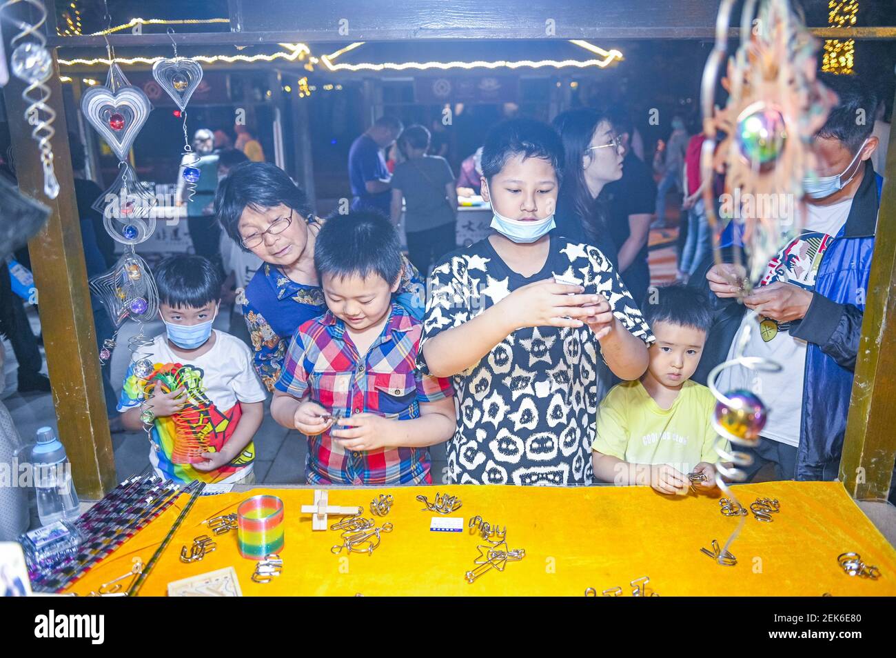 Kids play with loop rings at the Huayue Night Market opened by the Slender West Lake in Yangzhou ...