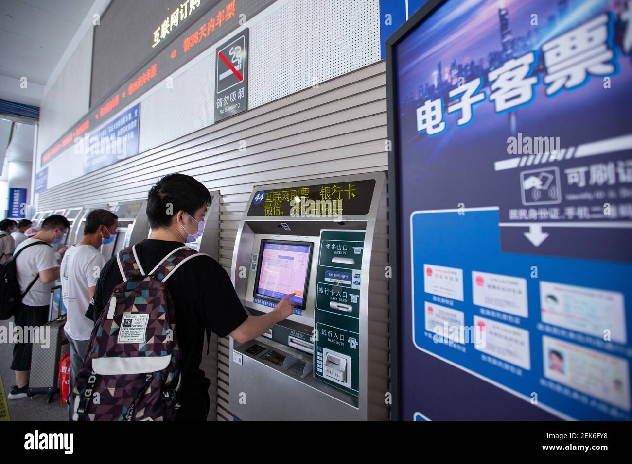 Passengers purchase e-tickets through self-service ticket machines in ...