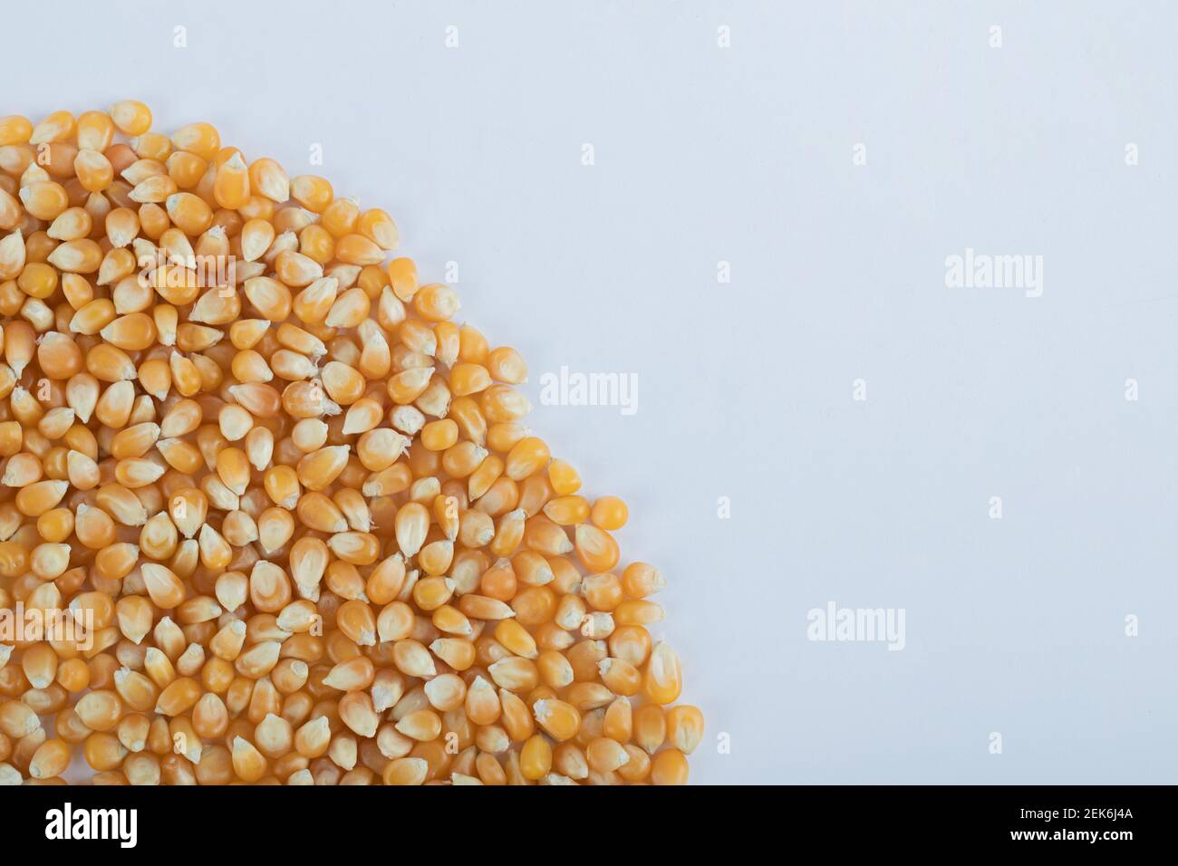 Heap of uncooked corn grains on a white background Stock Photo - Alamy