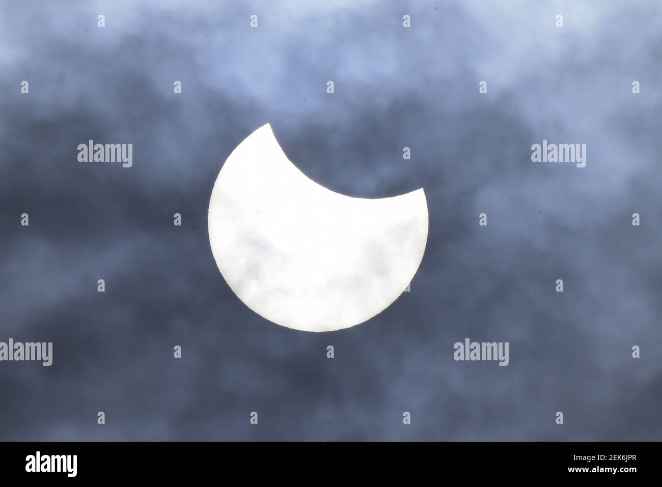 NEW DELHI, INDIA – JUNE 21: The sun shines amid the clouds as the moon ...