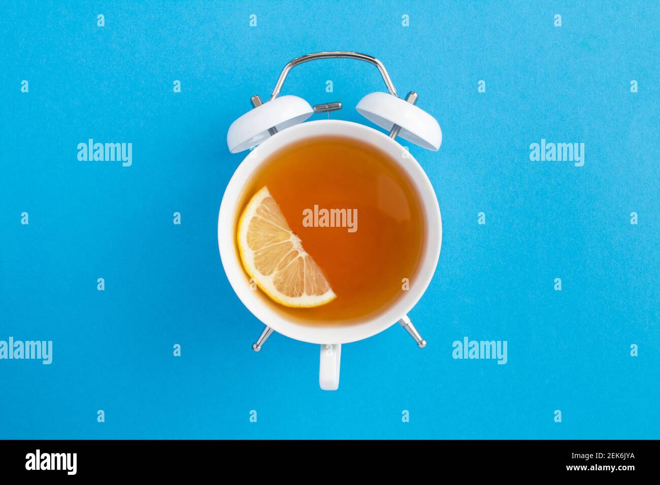 Top view of tea on the dial of the white alarm clock in the center of ...