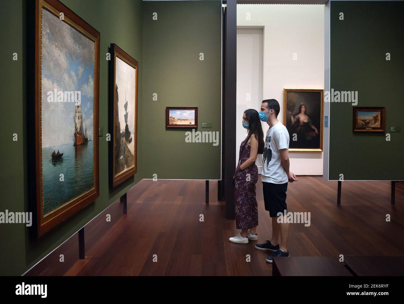 A couple wearing face masks is seen looking at paintings at Aduana ...