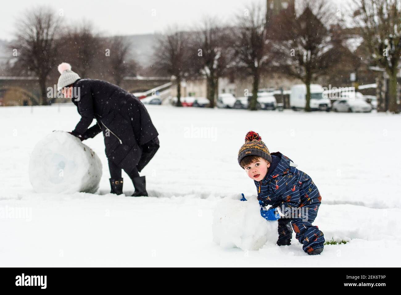 3 year old Frankie and mother Wendy Dunn roll a snowman together in ...
