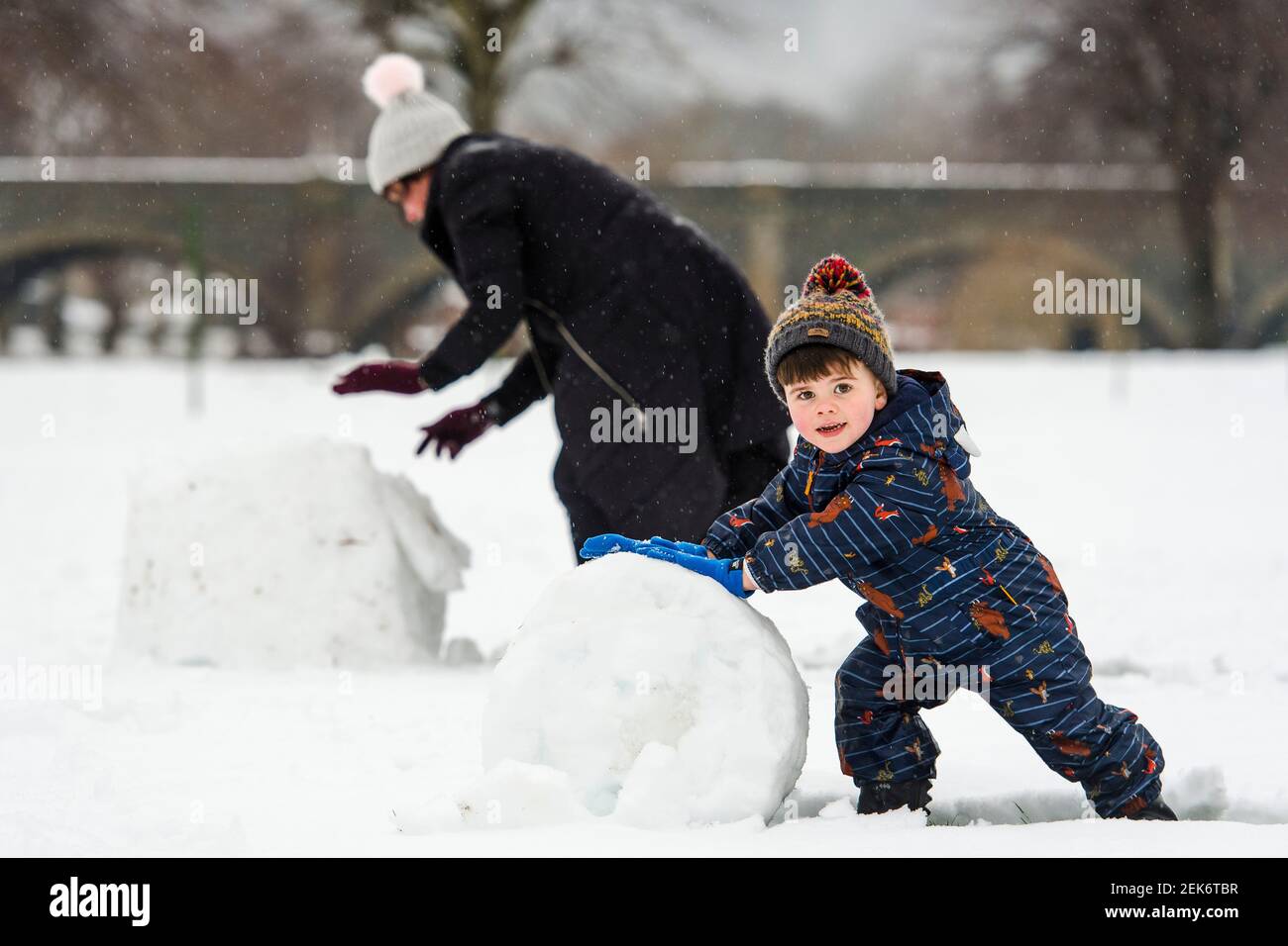 3 year old Frankie and mother Wendy Dunn roll a snowman together in ...
