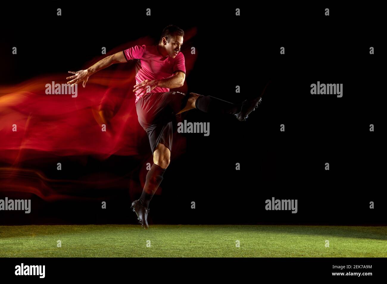 Powerful, flying above the field. Young football, soccer player in ...