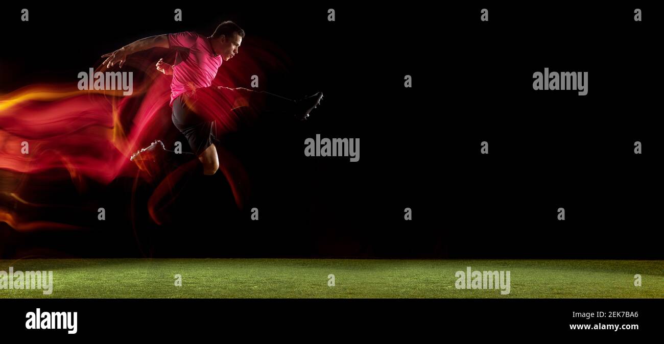 Powerful, flying above the field. Young football, soccer player in ...