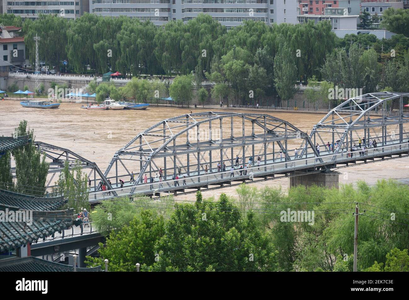 People walk on a bridge over the Yellow River Lanzhou section in ...