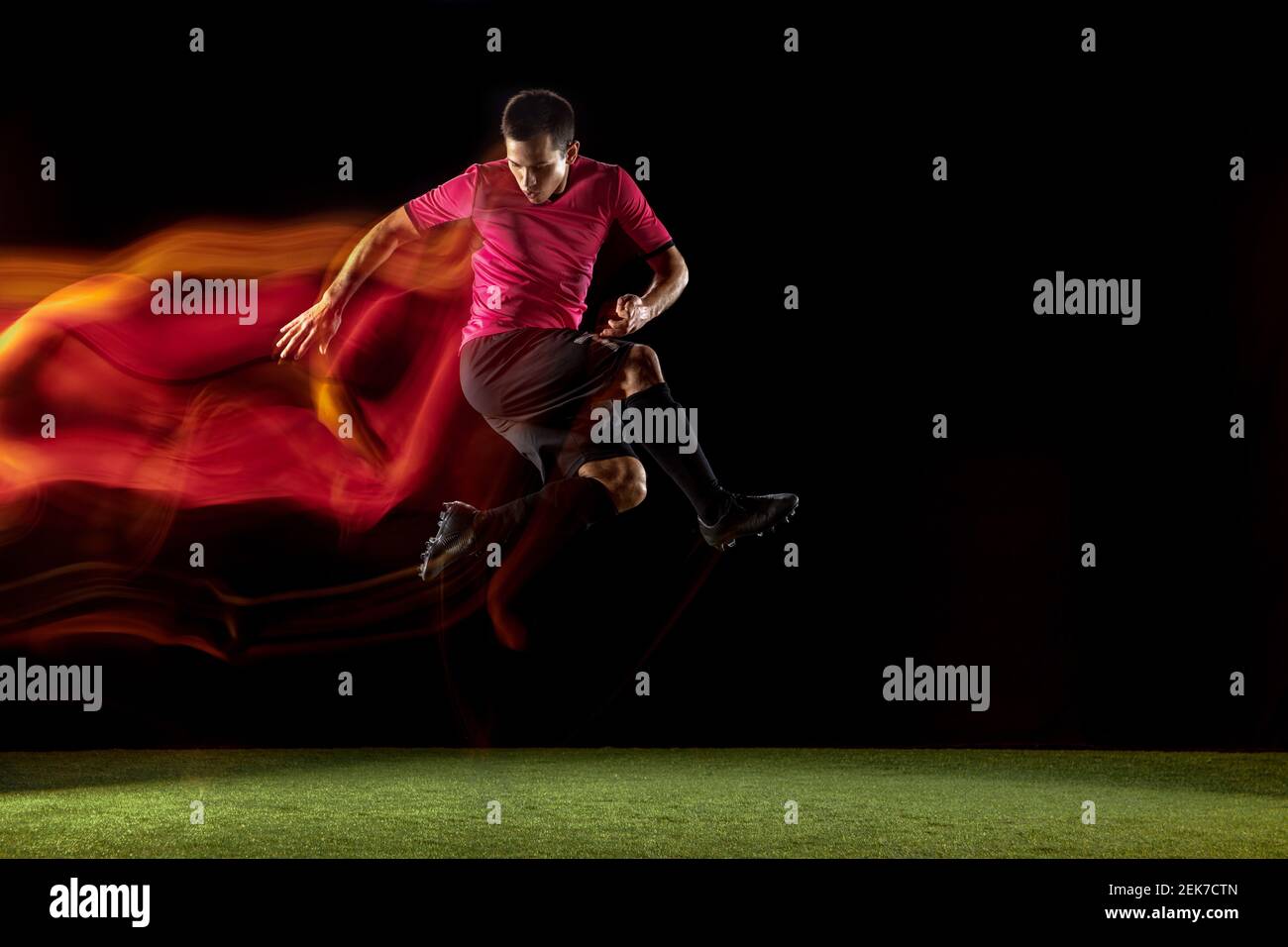 Powerful, flying above the field. Young football, soccer player in ...