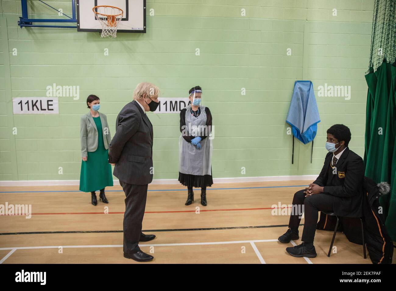 Prime Minister Boris Johnson (left) speaks a student in the gym, which ...