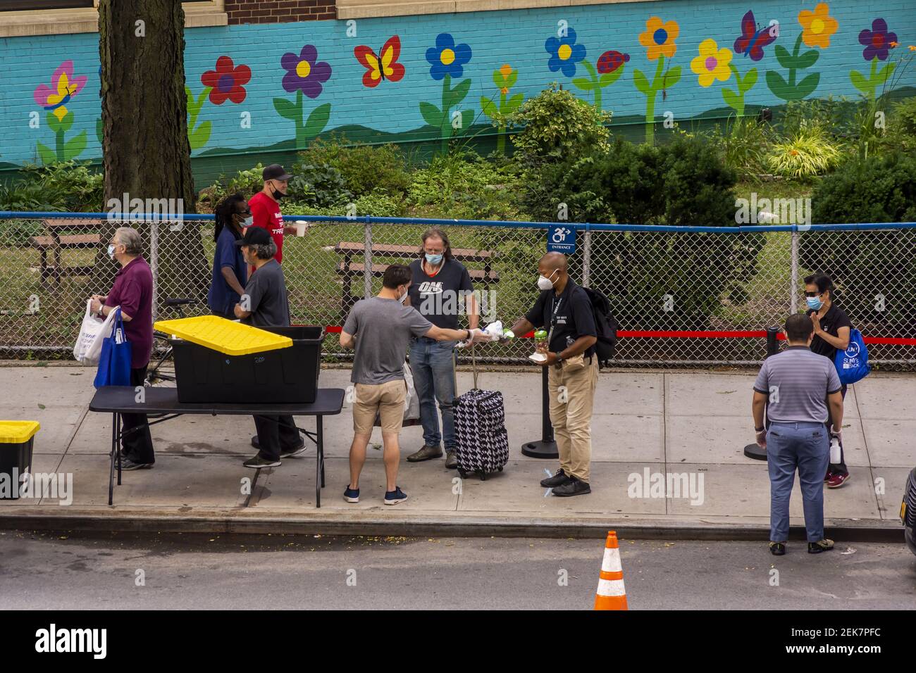 People in need line up for clothing and food at the Relief Bus social ...