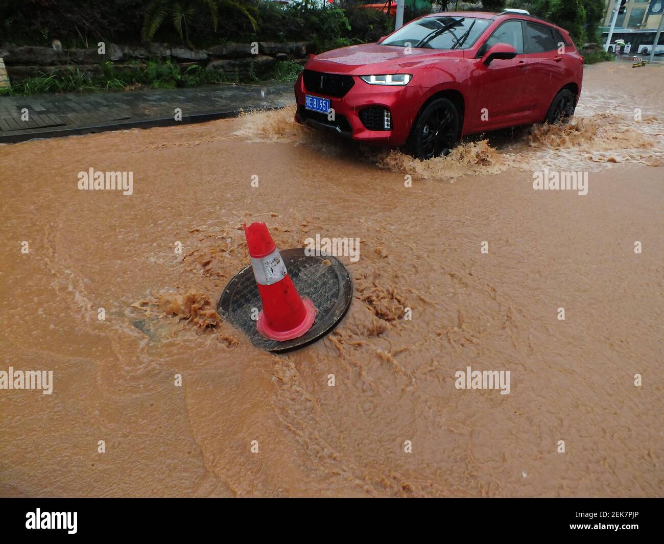 A manhole cover is pushed aside by rising underground water level ...