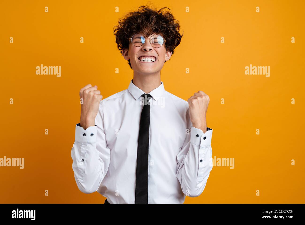 Happy excited male student standing wearing uniform isolated on a ...