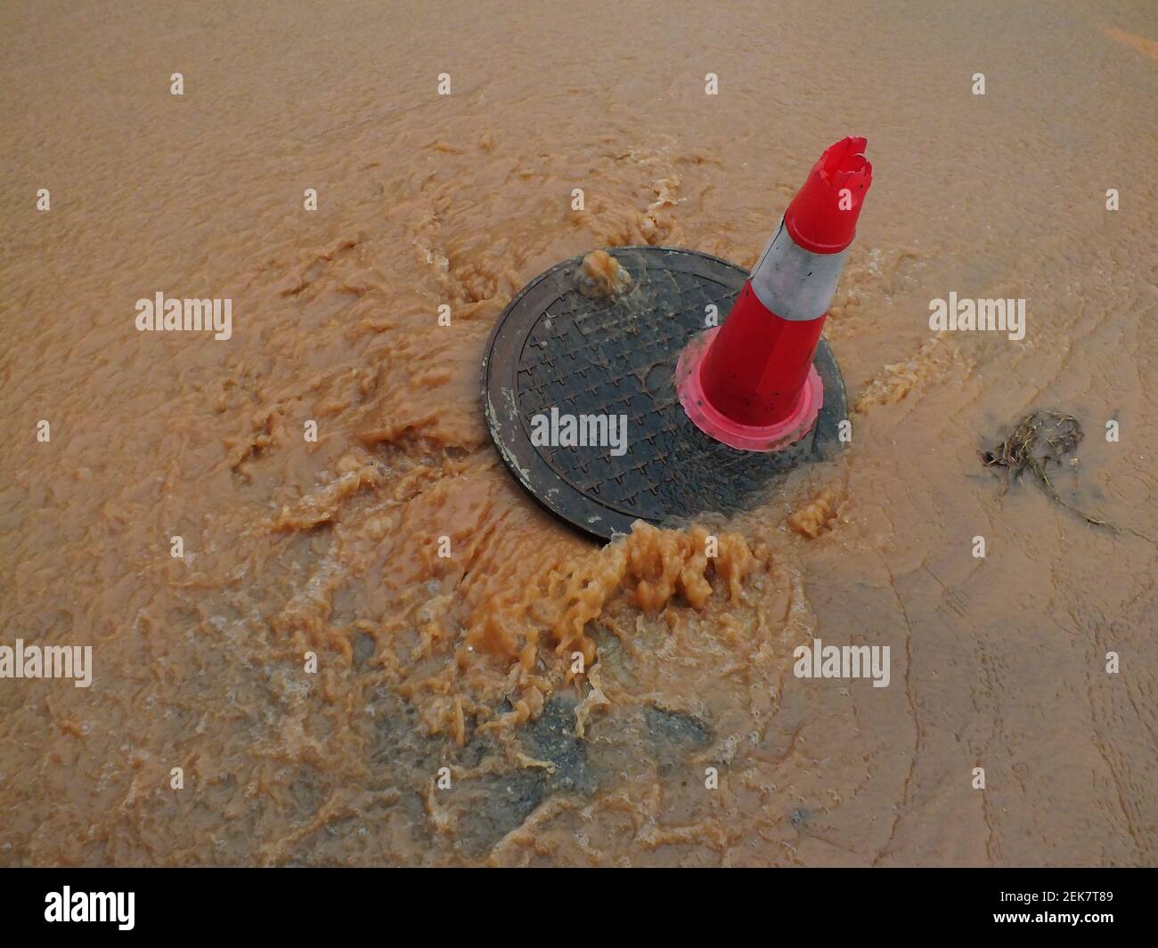 A manhole cover is pushed aside by rising underground water level ...