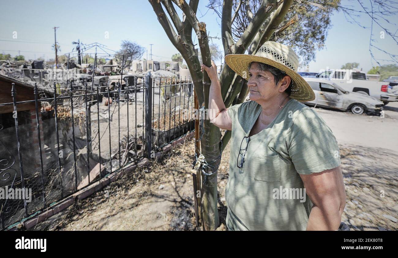 Ana Valenzuela stares at the pile of ashes and debris where her home ...