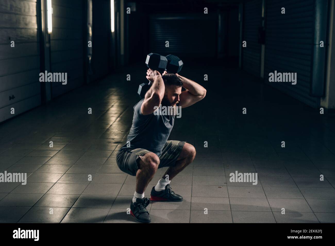 Side view of muscular attractive caucasian bearded man doing squats ...