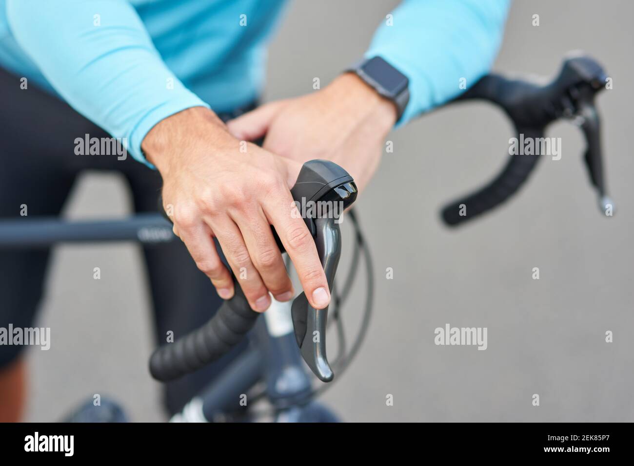 Close up shot of hands on handlebar. Professional male cyclist wearing ...