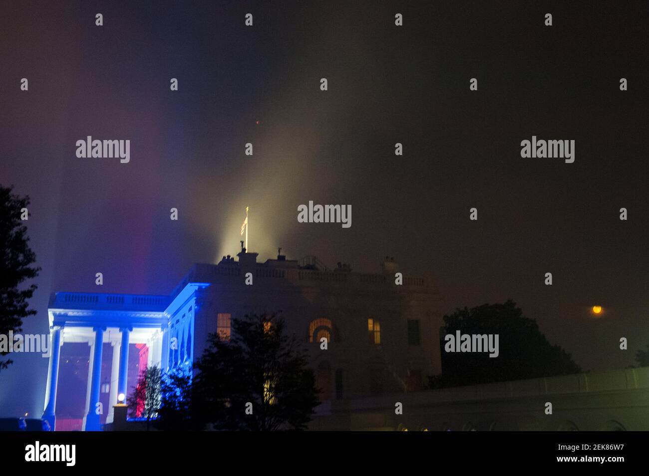 The White House, lit up in July 4th colors, is partially shrouded in ...