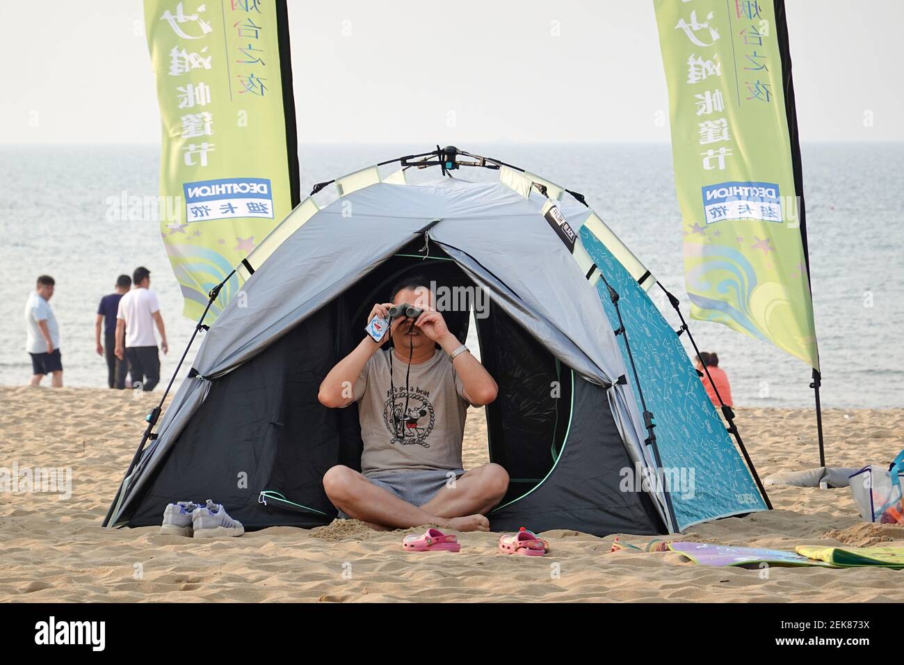 YANTAI, CHINA - JULY 4, 2020 - A tourist attending the beach tent ...