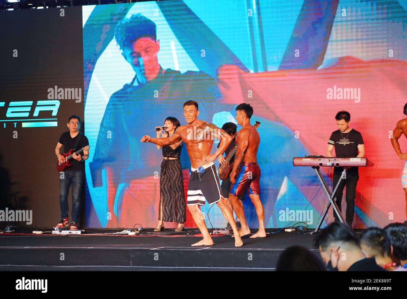 Male participants pose to show their muscle and body during a ...