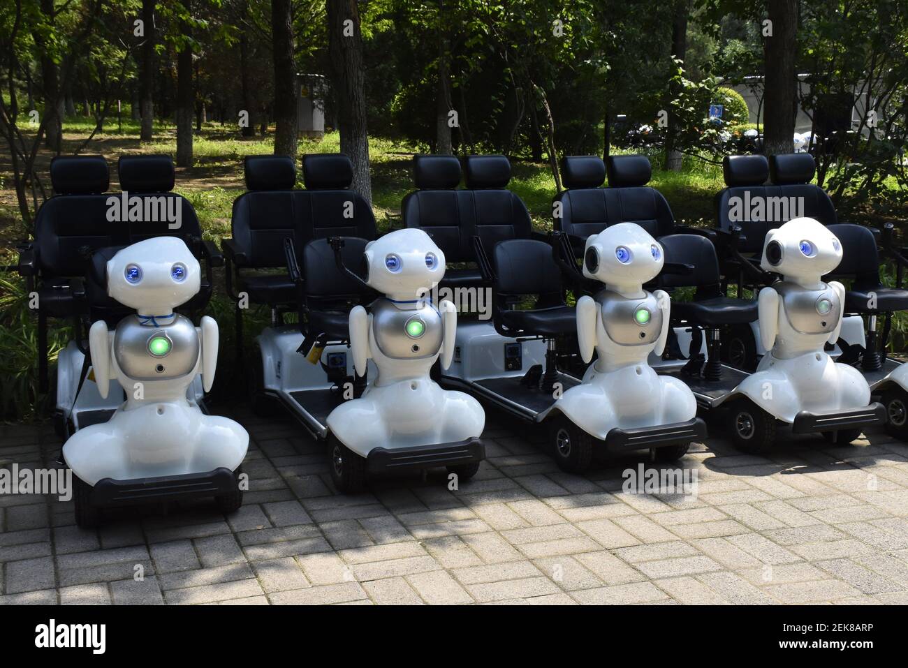 People ride on the robots designed for tour guide at the Olympic Forest ...