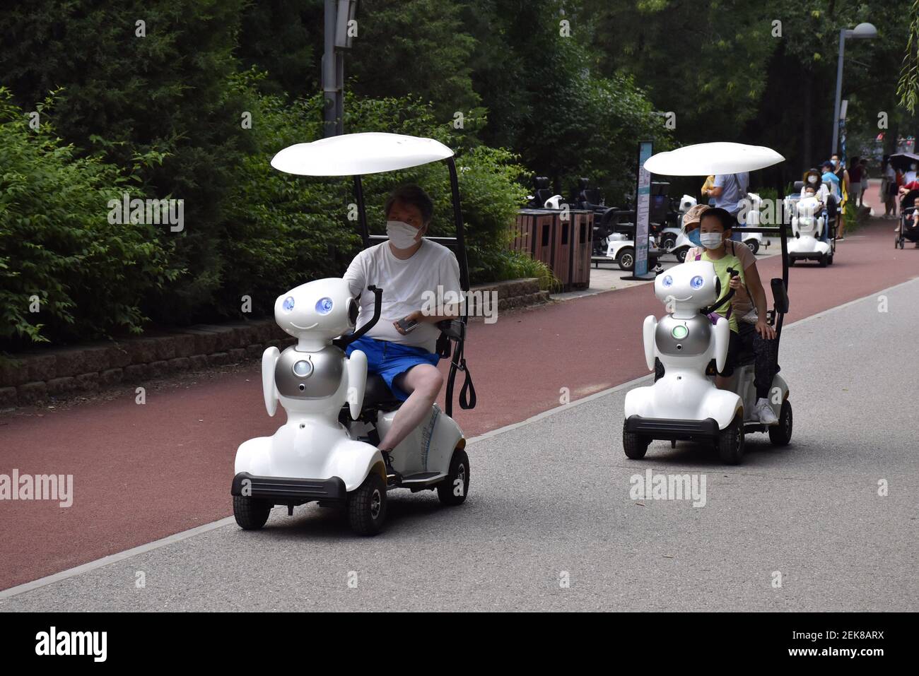 People ride on the robots designed for tour guide at the Olympic Forest ...