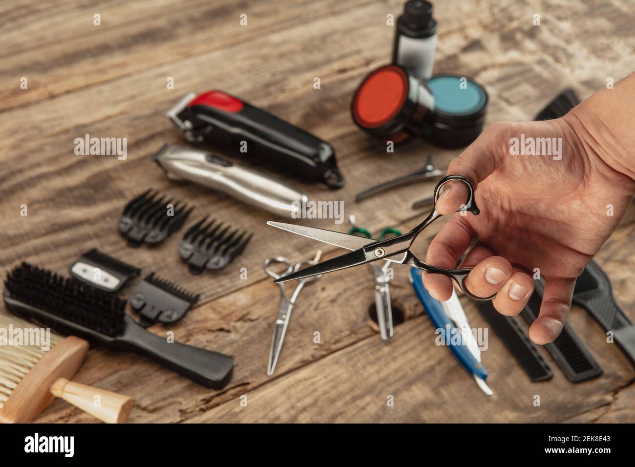 Hand of barber with equipment set on wooden table background. Close up ...