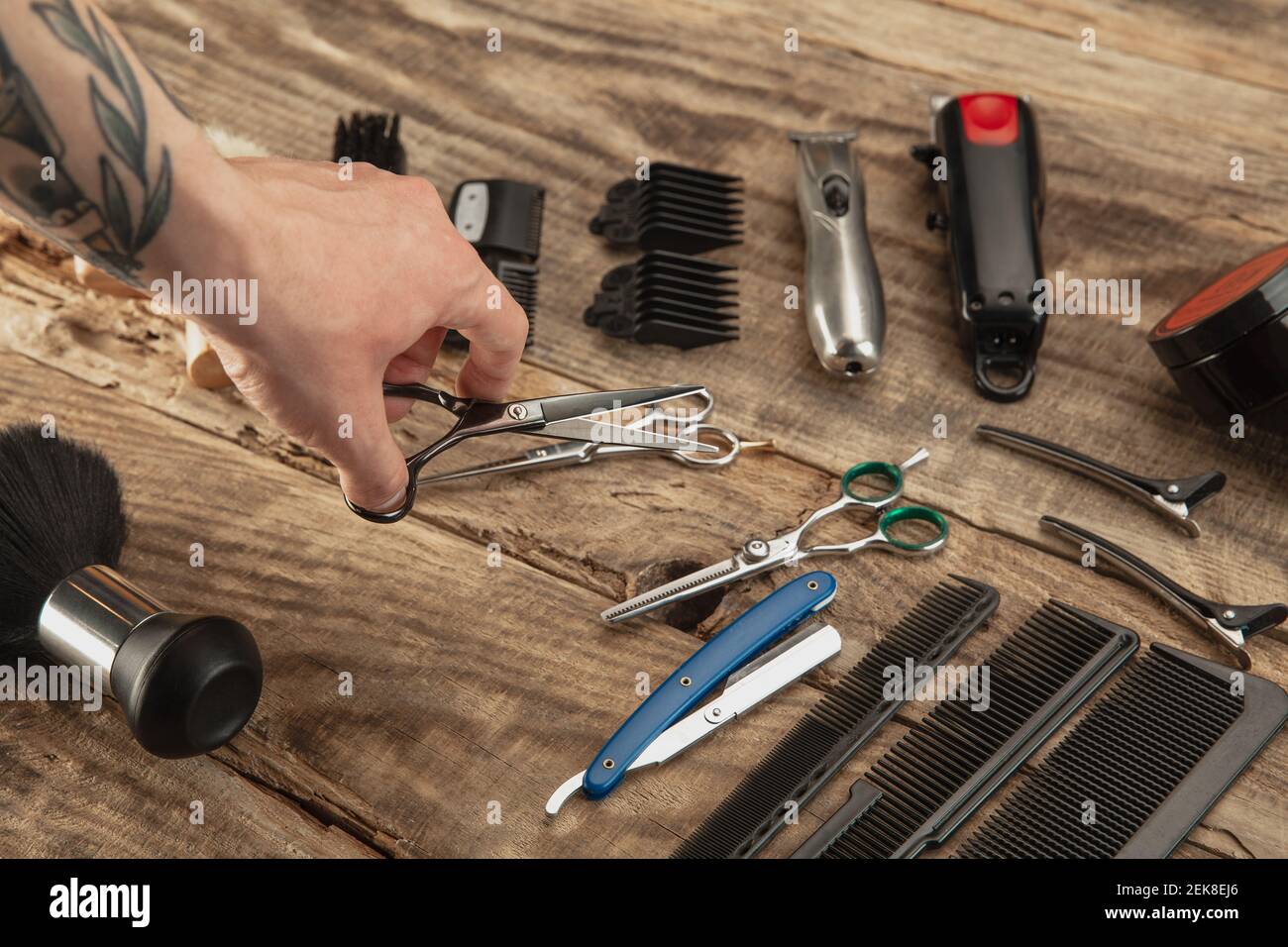 Hand of barber with equipment set on wooden table background. Close up ...