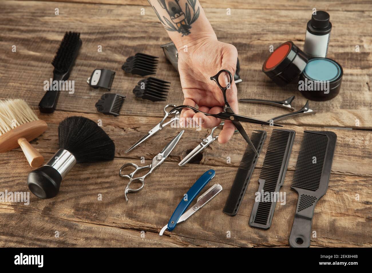 Hand of barber with equipment set on wooden table background. Close up ...
