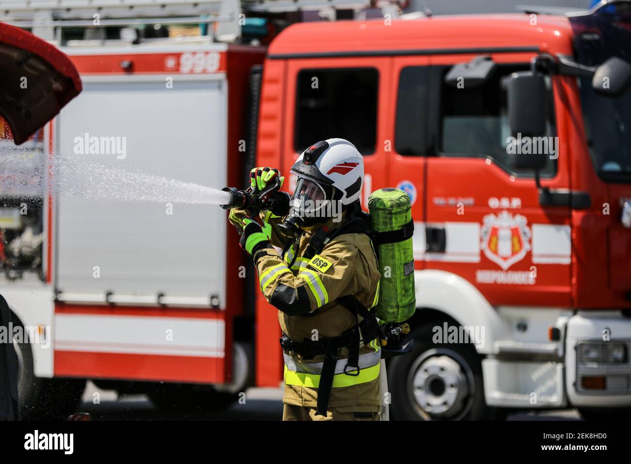 A firefighter in heavy equipment putting out the fire during the ...