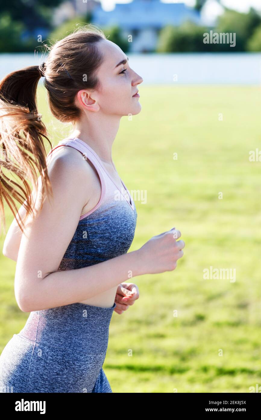 Happy track running girl runner getting ready for cardio training run ...