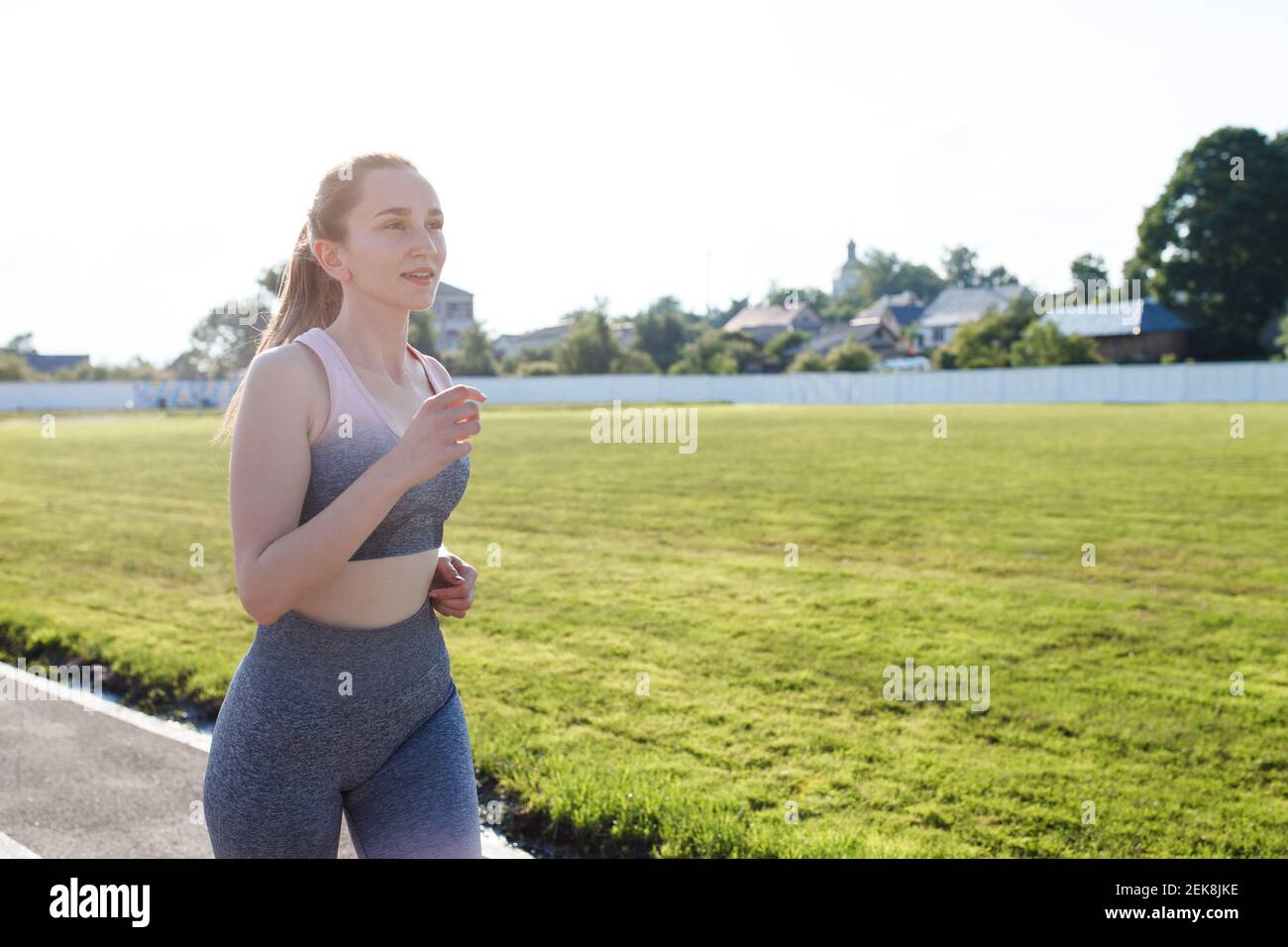 Happy track running girl runner getting ready for cardio training run ...