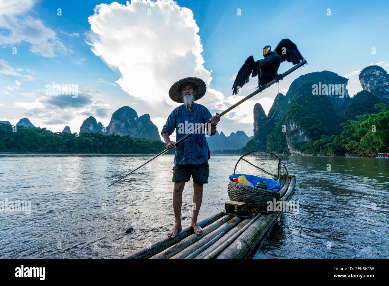 In this undated photo, an old fisherman and his cormorant fish on a ...