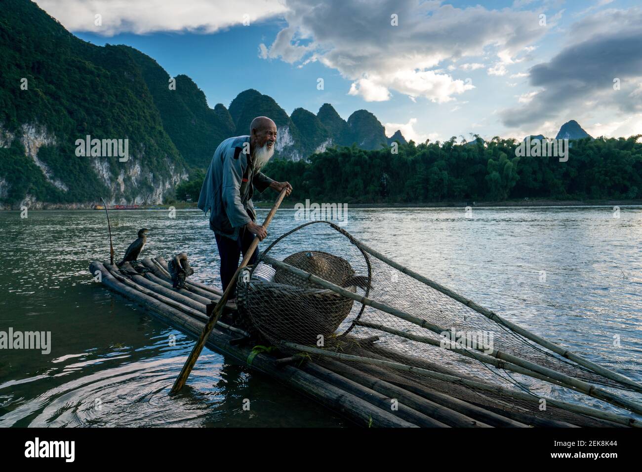 In this undated photo, an old fisherman and his cormorant fish on a ...
