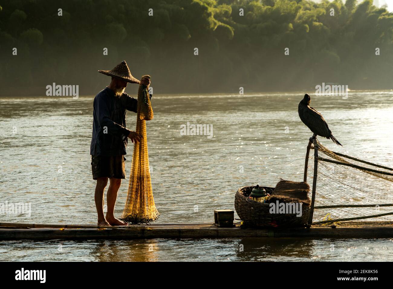 In this undated photo, an old fisherman and his cormorant fish on a ...