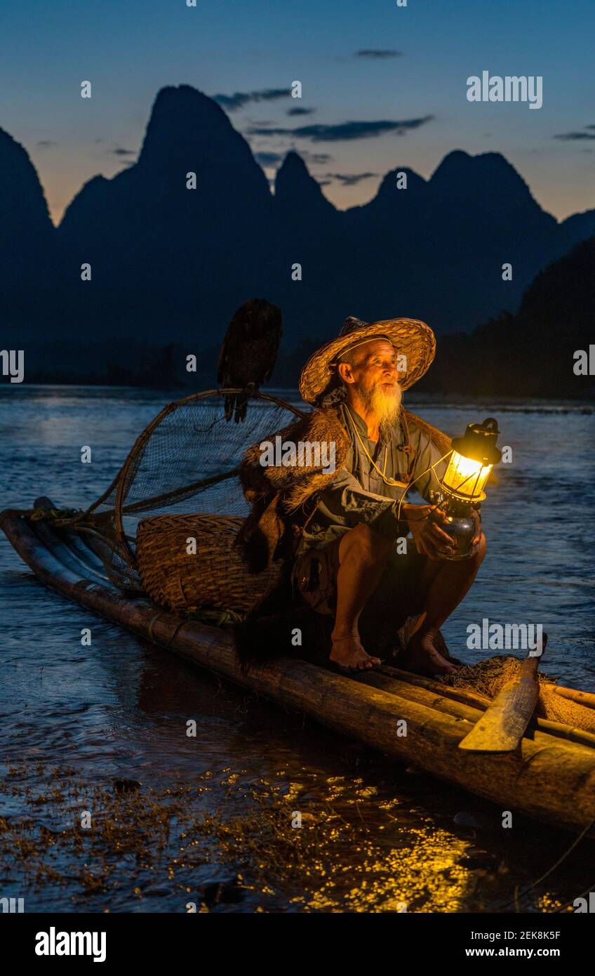 In this undated photo, an old fisherman and his cormorant fish on a ...