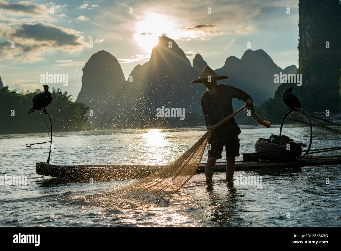 In this undated photo, an old fisherman and his cormorant fish on a ...