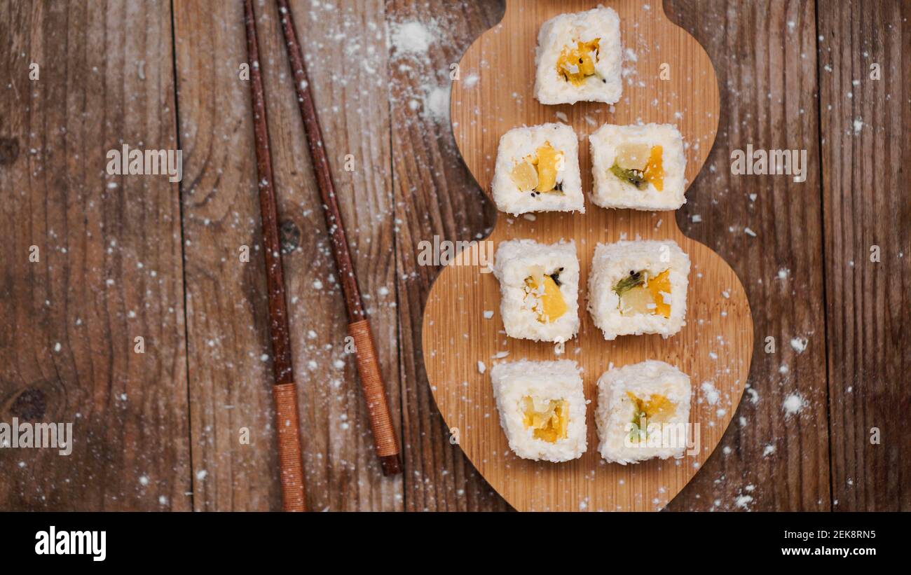 Sushi delivery. Sweet rolls made from rice, pineapple, kiwi and mango ...