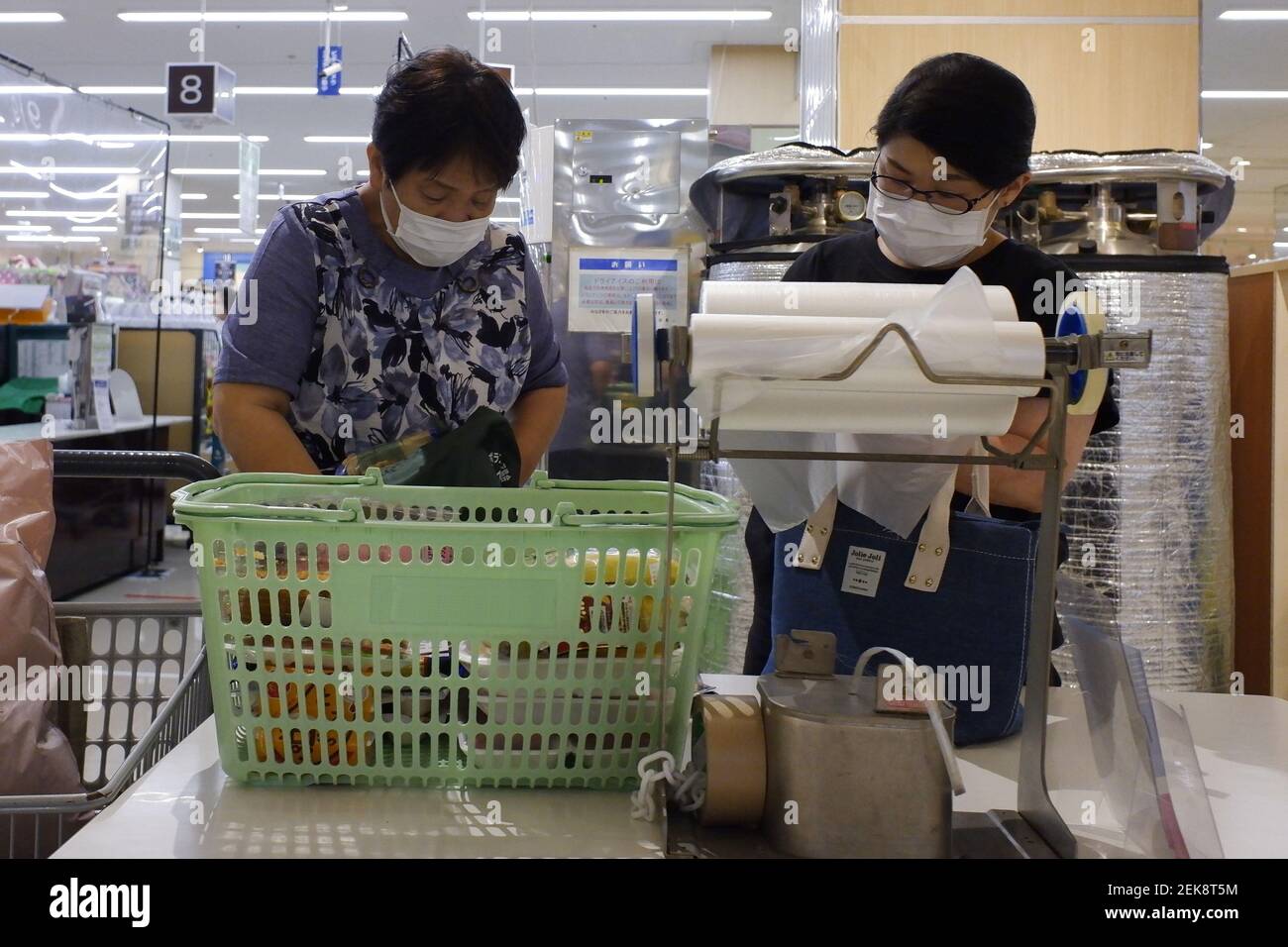 People wear face masks as a preventive measure while shopping at AEON ...