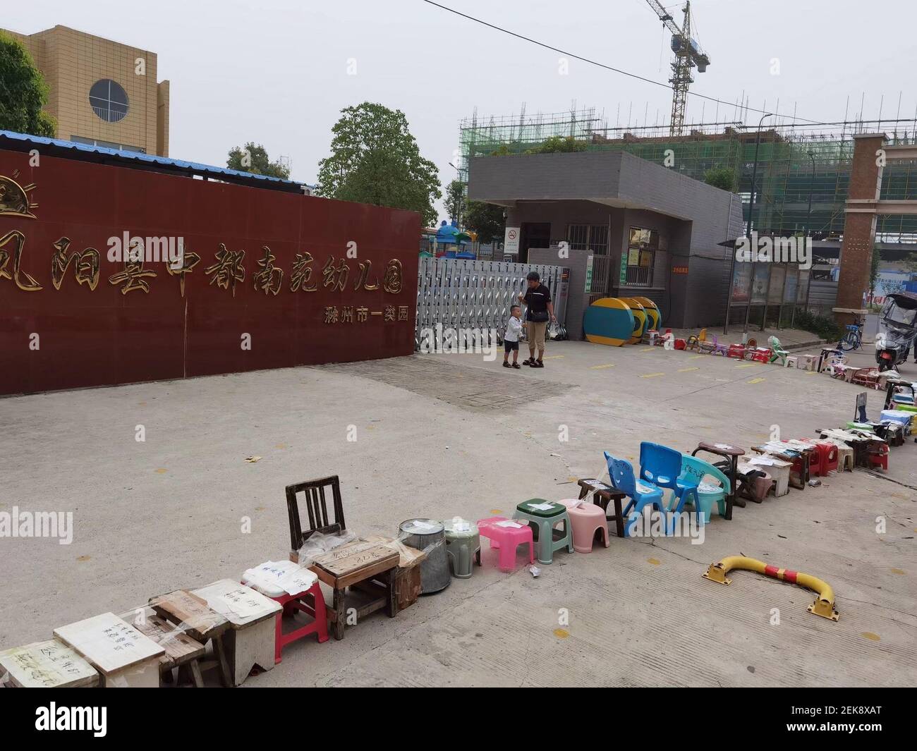 A line of chairs are used by parents as a line-up seat occupation sign ...