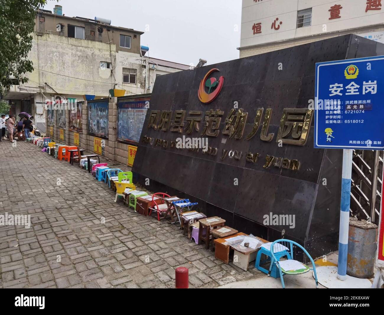 A line of chairs are used by parents as a line-up seat occupation sign ...
