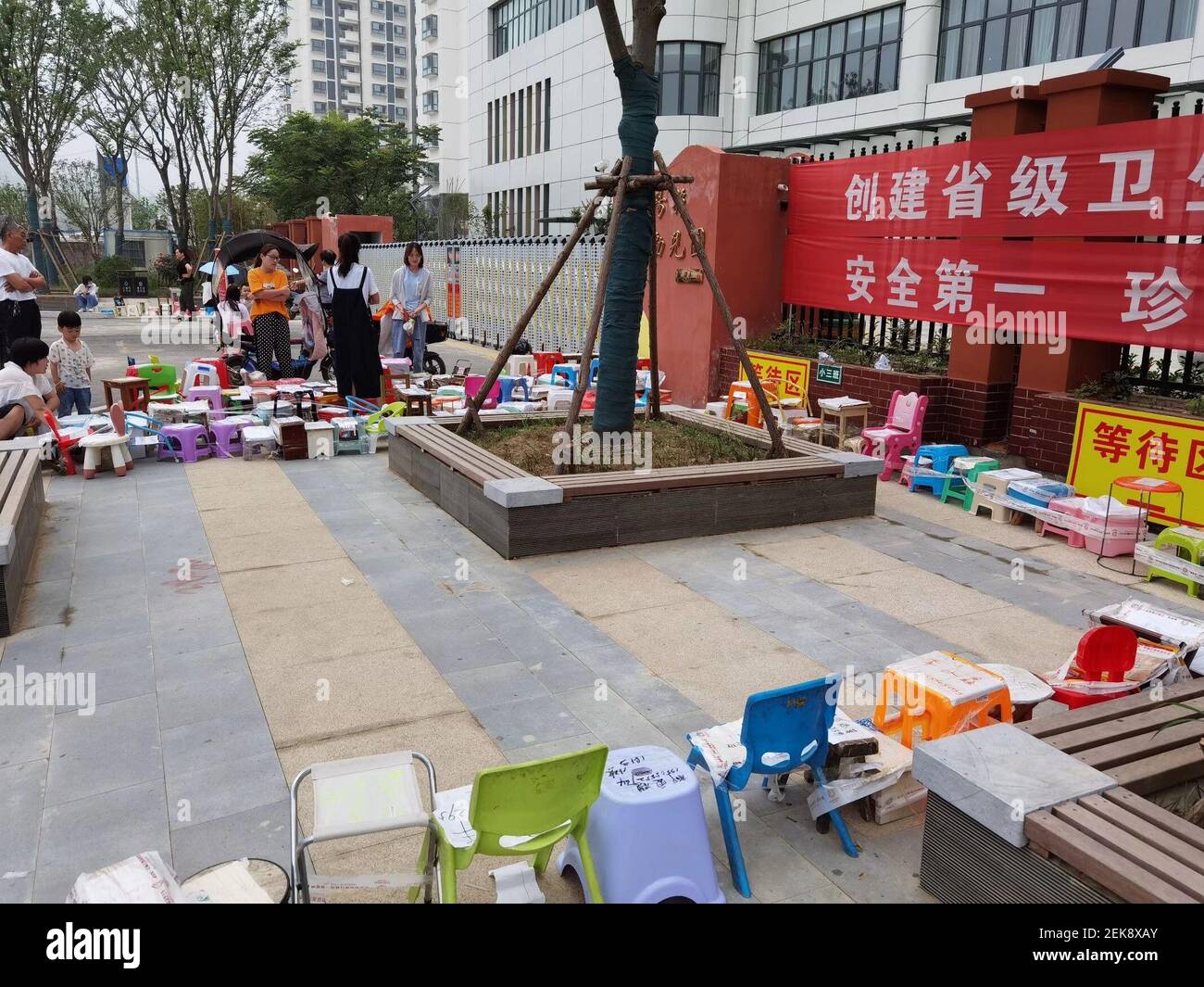 A line of chairs are used by parents as a line-up seat occupation sign ...