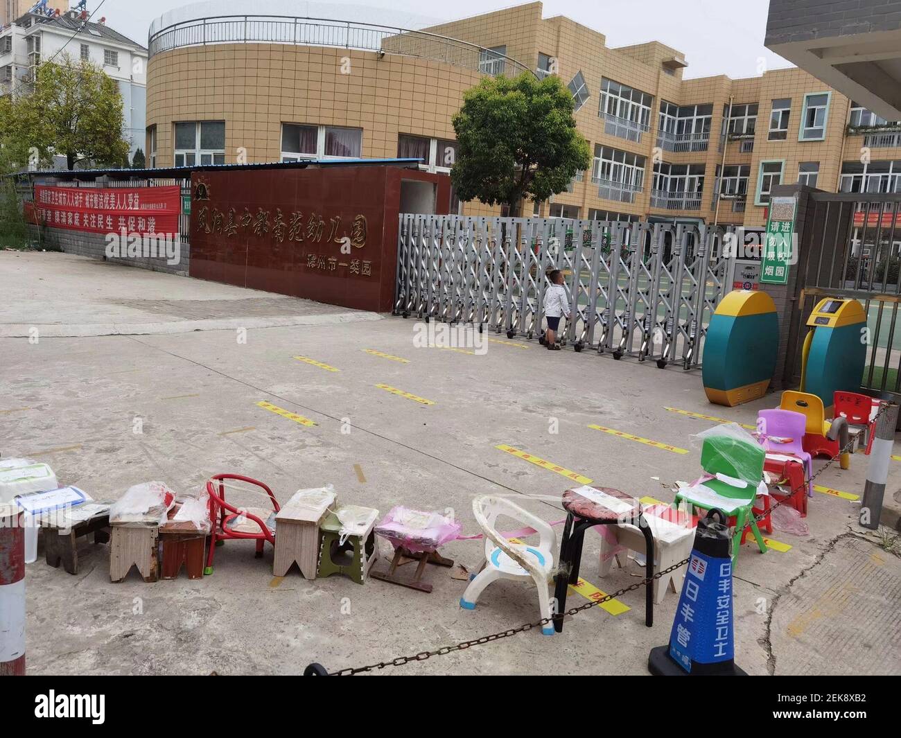 A line of chairs are used by parents as a line-up seat occupation sign ...