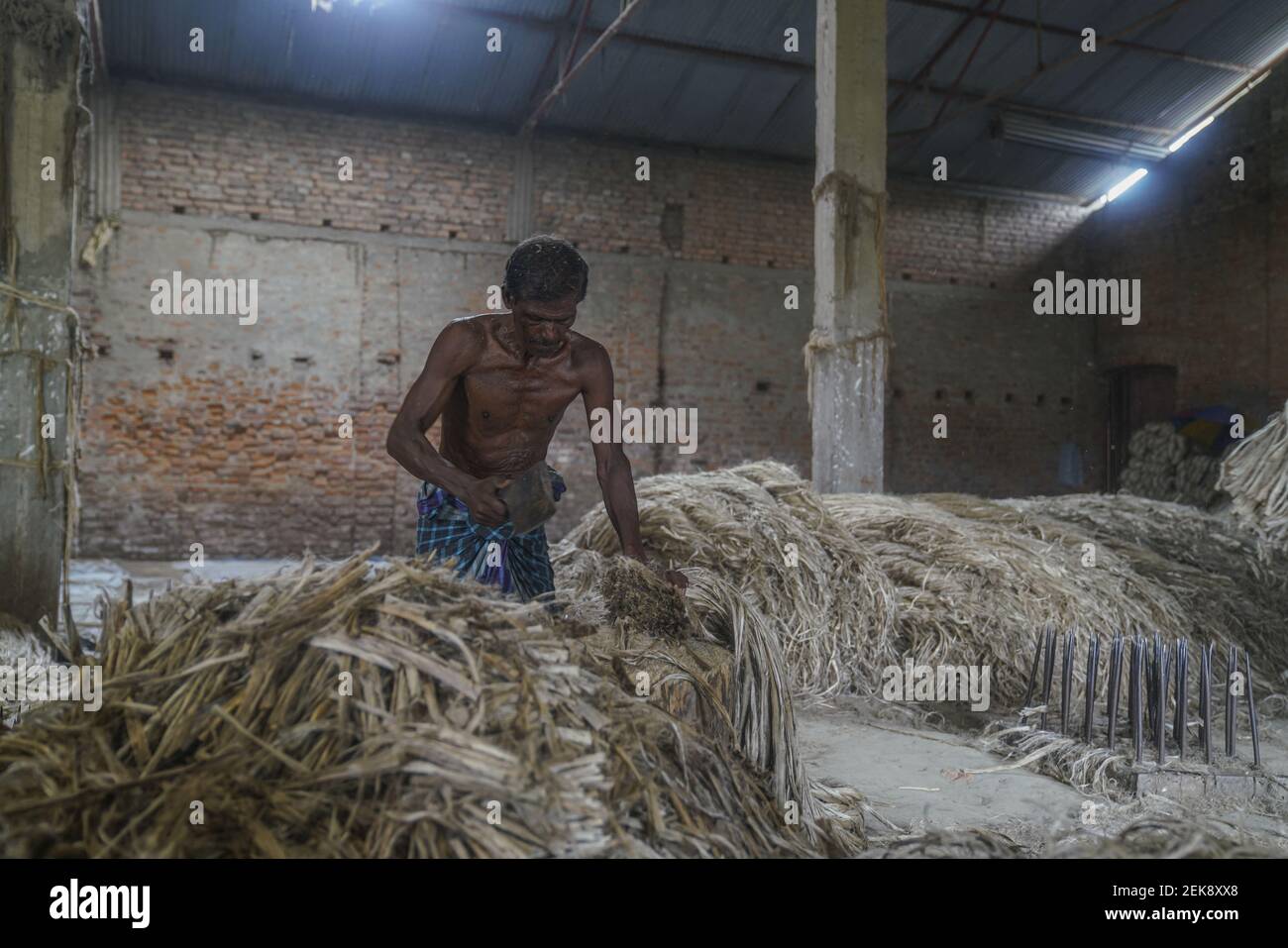 A man working at a jute processing factory in Narayanganj near Dhaka ...