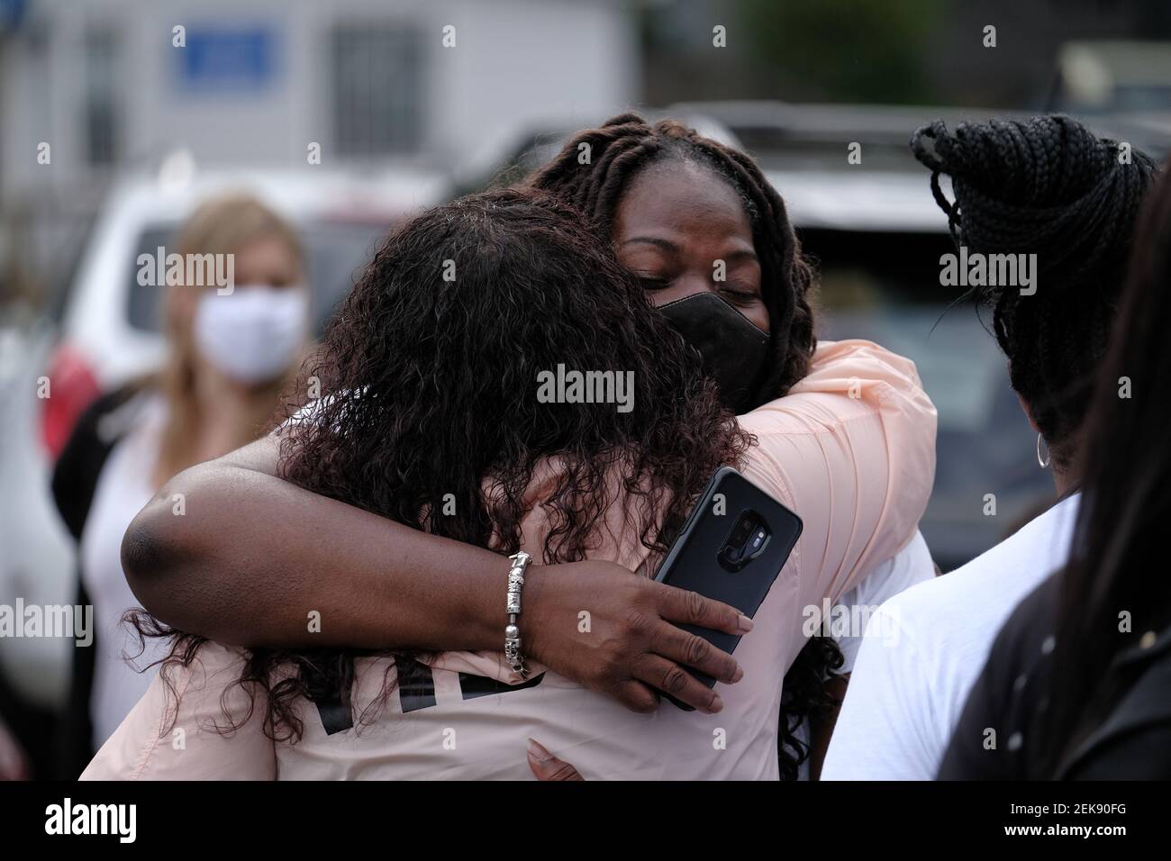 A woman hugs the mother of Dominique Dunn as family and friends gather ...